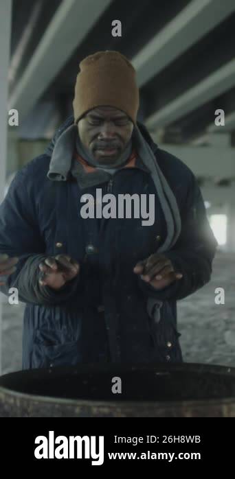 Vertical view of homeless African American senior man wearing jacket ...