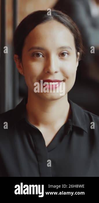 Vertical chest-up portrait of young businesswoman wearing black shirt ...