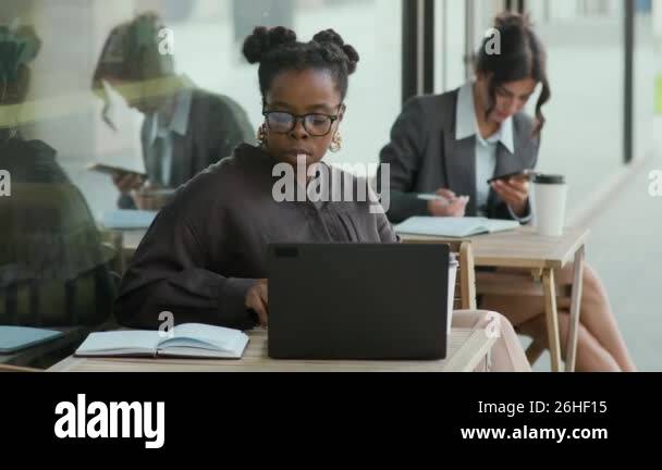African American female CEO in formal outfit writing in her notebook ...