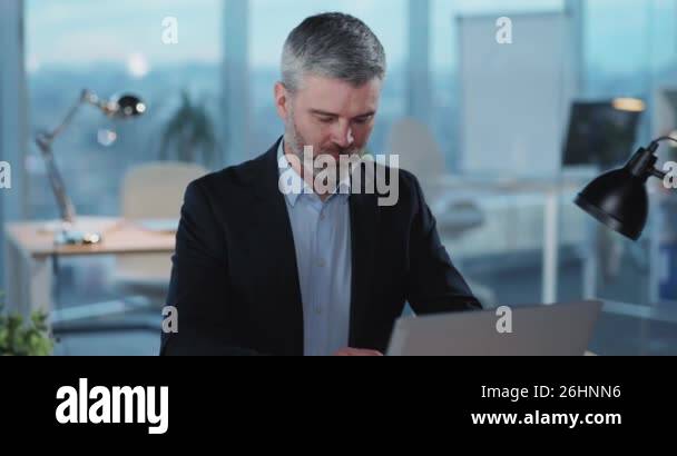 Portrait of successful caucasian adult in formal black suit finishing ...