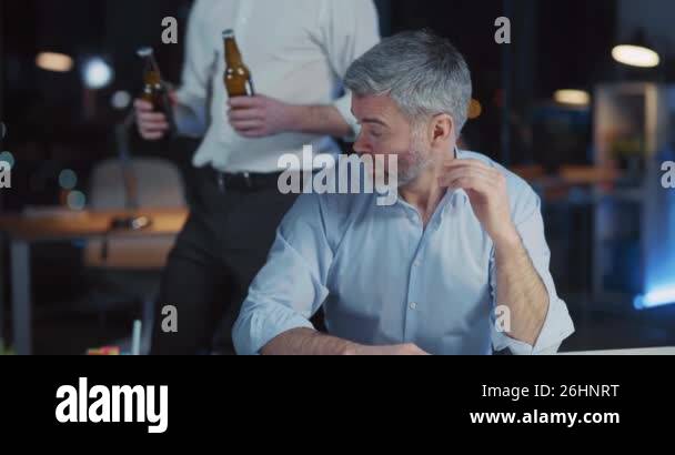 Caucasian funny couple of drunk businessmen drinking alcohol beer in ...