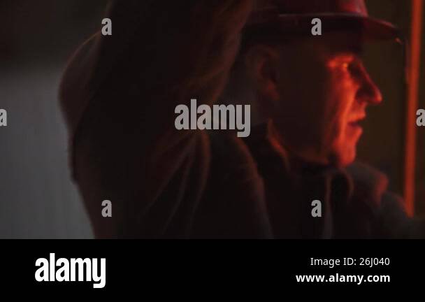 A focused worker is illuminated by a machines bright light while ...