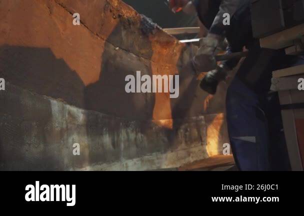 A skilled technician works in a large industrial space, performing ...