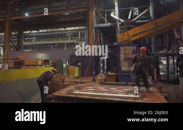 Workers engaged in various operations within a busy industrial setting ...