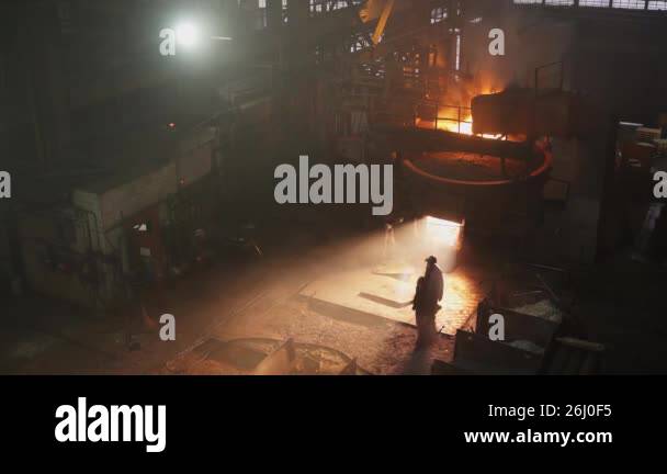 An industrial scene with hardworking employees in a dark factory ...