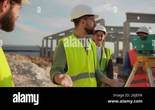 Engineers team with helmet and uniform talking about a construction project clap theirs hands ...