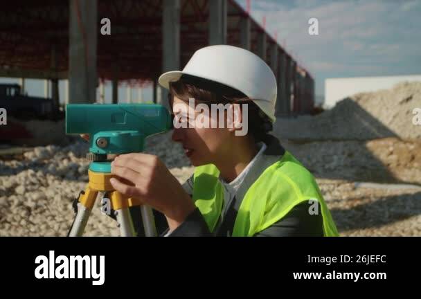 Shot of focused young female topographer at work. Woman in protective ...