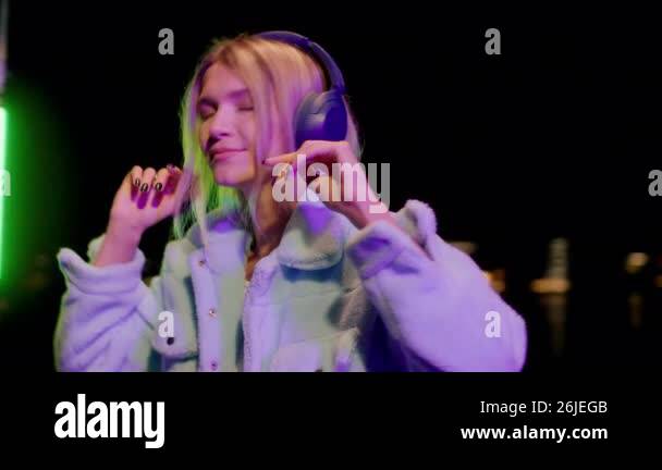 Portrait of gorgeous woman wearing headphones listening music. Dancing ...