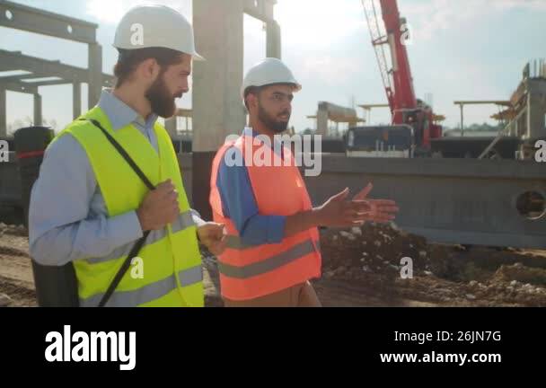 Side shot of young Caucasian and Turkish male topographers walking ...