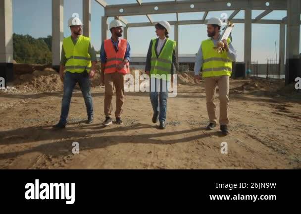 Smiling footage of smiling construction workers in bright vests and ...