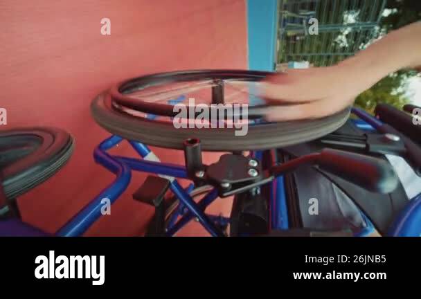 Close-up of wheelchair. Male hands turning wheel. Outdoor. Sports ...