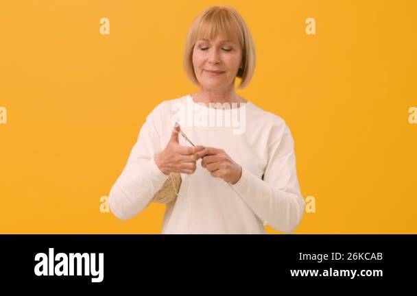 An older woman enjoying a moment of creativity while knitting with ...