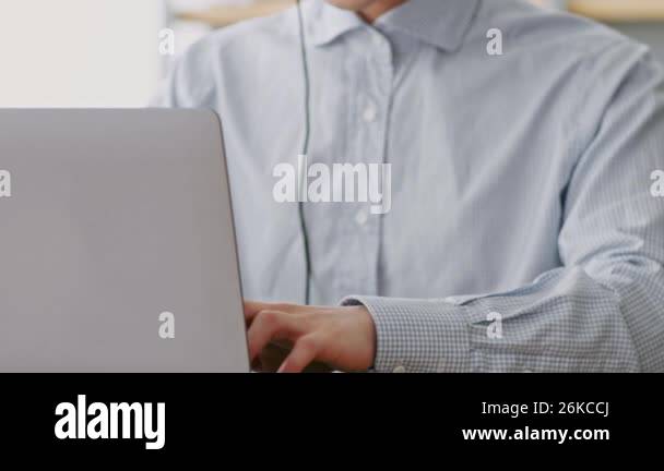 A young man of Asian descent is focused on his work at a sleek home ...