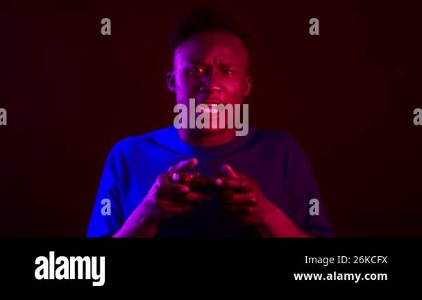 A handsome millennial man intensely focuses on gaming while holding a ...