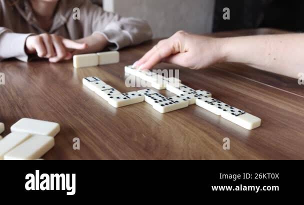 Friends play dominoes in the comfort of home. Play logical game domino ...