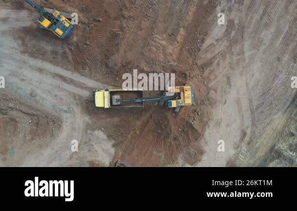 Aerial shot of site mining ground. Drone flying over excavators digging ...