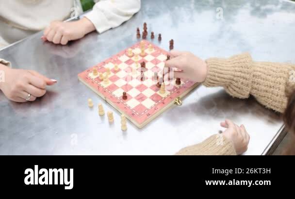 Friends enjoy a competitive game of chess outdoors on a sunny day ...