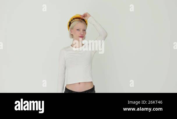 Model poses confidently in a yellow construction helmet on a white ...