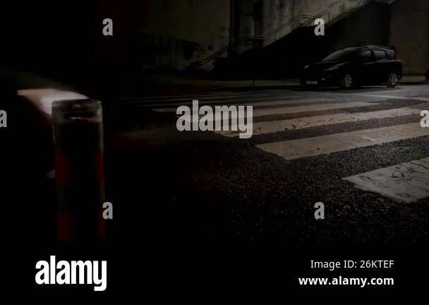 Flashing light signal on a pole near a pedestrian crossing at night ...