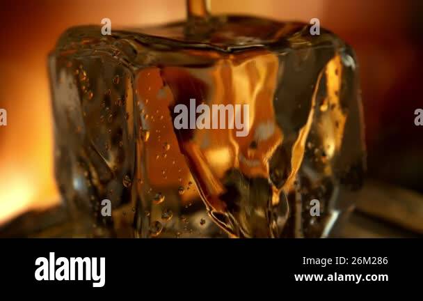 Super Slow Motion Detail Shot of Pouring Whiskey on Ice Cube in Glass at 1000fps. Filmed with ...