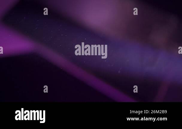 Dust particles floating in the air illuminated by ambient purple studio ...