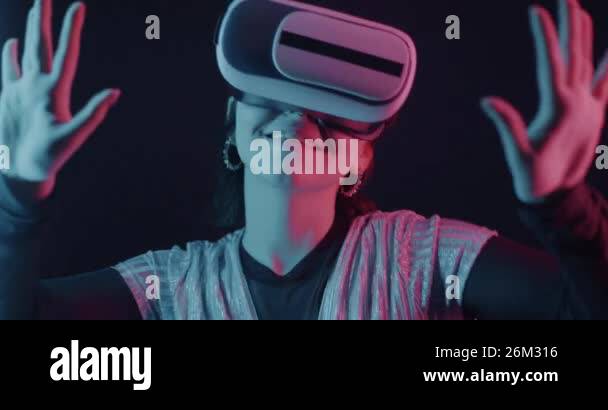 Slow motion of girl in virtual reality glasses dancing in neon light on ...