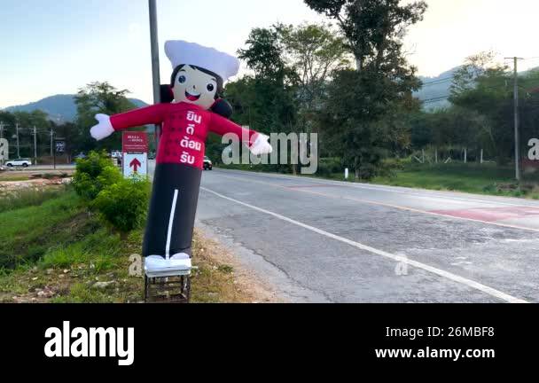 Inflatable chef waves as cars drive by Stock Video Footage - Alamy