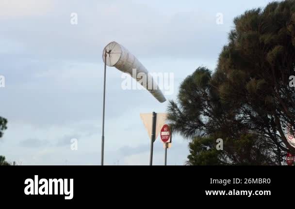 Windsock swaying near trees and road signs Stock Video Footage - Alamy