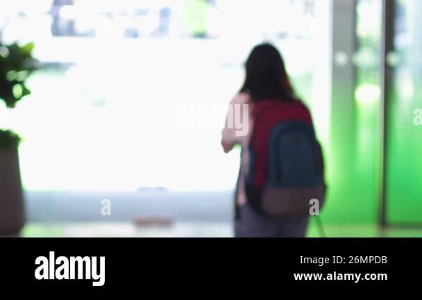 Person walking towards and exiting through sliding glass doors Stock ...