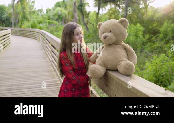 Cute child girl having communication with her teddy bear friend ...