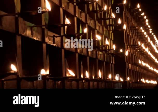 The traditional perimeter wall of an Indian temple is lit up with oil ...