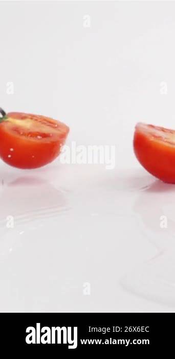 Two red tasty fresh wet halves of tomatoes with green gras tail ...