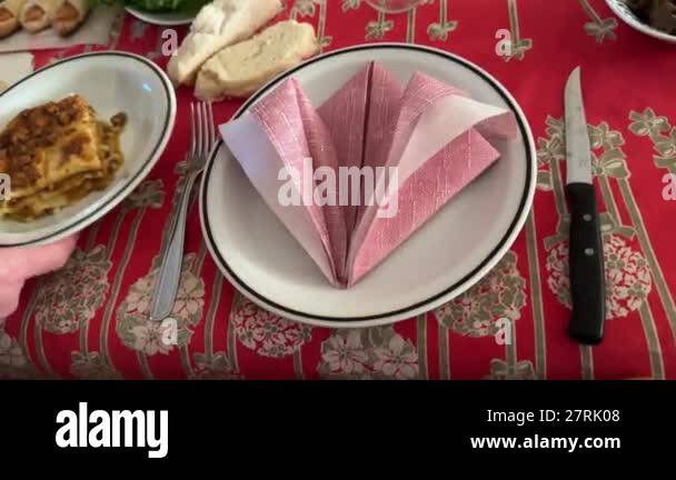 Festive table with red tablecloth progressively filling with lasagna ...