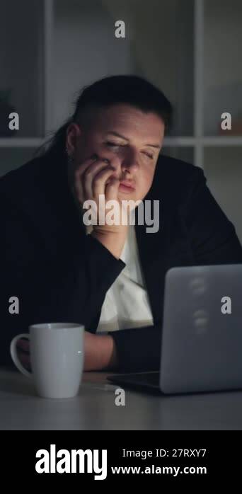 Vertical video. Overworked manager. Night job. Tired unhappy female ...