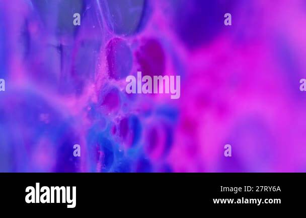 Vertical video. Bubble fluid. Wet foam. Defocused neon pink purple blue ...