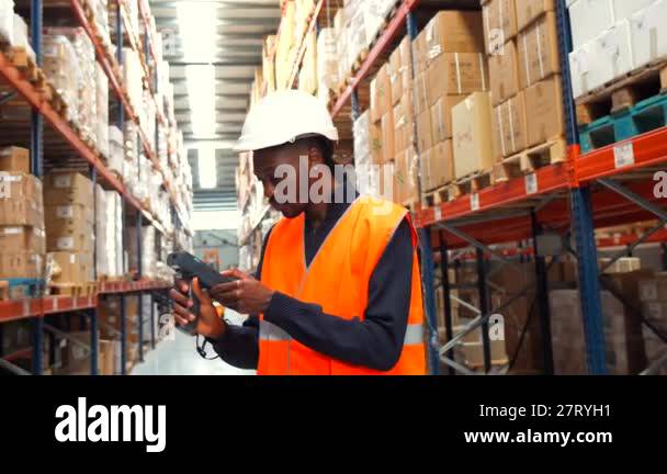 Logistics worker scanning packages in a warehouse using a barcode ...
