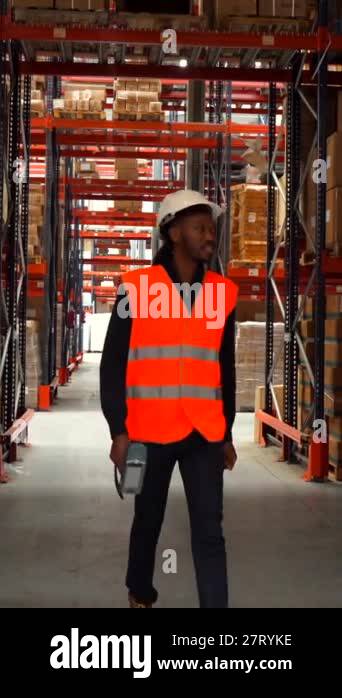 Logistics operator wearing an orange safety vest and white hardhat ...