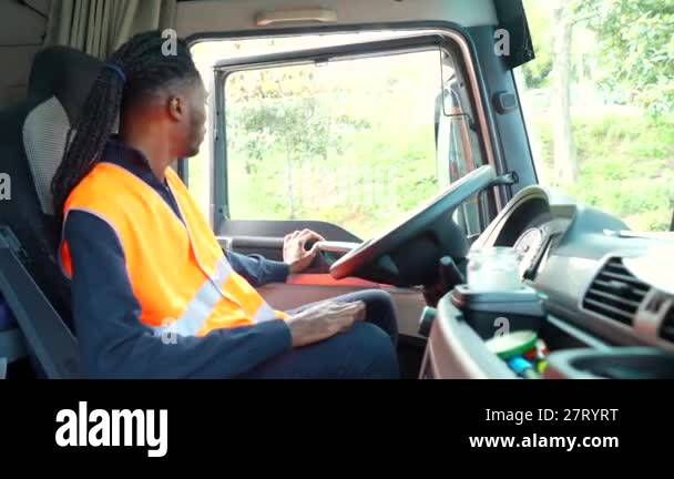 Young man truck driver wearing safety vest, preparing for delivery ...