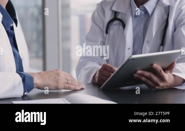 Two doctors using tablet, lead professional discussion regarding ...