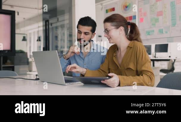 Teammates involved in teamwork using laptop and digital tablet. Two ...