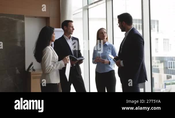 Four young multiethnic teammates lead conversation, reviewing client ...