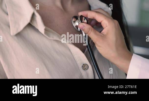 Female doctor listening to heartbeat rate and breathing of patient ...