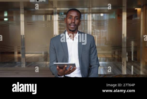 Portrait of young African professional staff member posing indoors ...