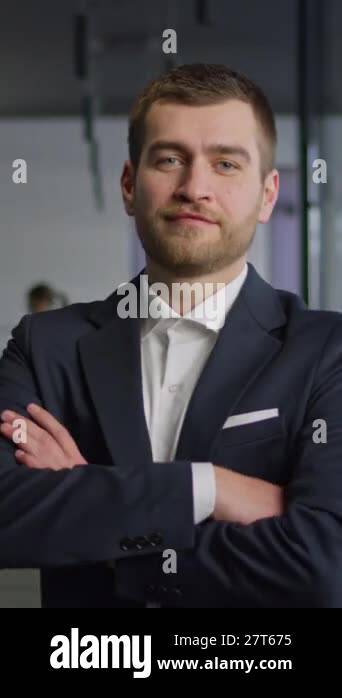 Vertical Screen: Confident young businessman in a suit standing in a ...