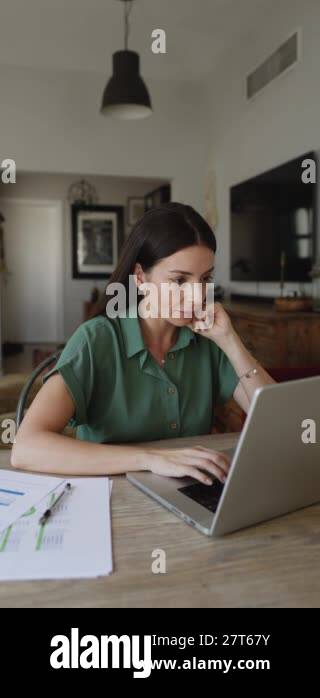 Vertical view woman working online using laptop, sit at table in living ...