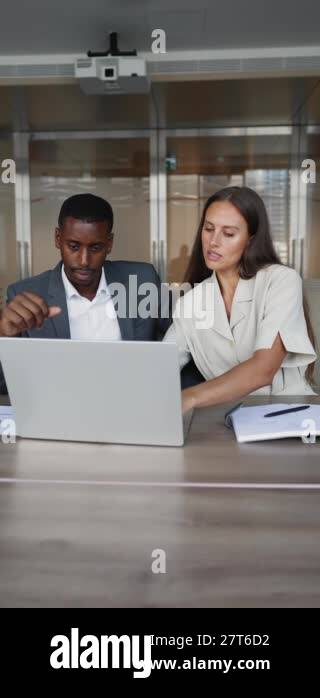 Two employees engaged in teamwork, joint project completion using ...