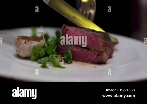 Cutting a delicious grilled ramp steak. Juicy meat with a lot of ...