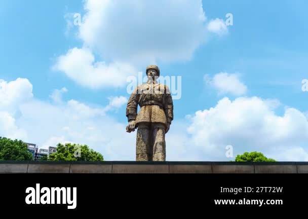 Statue of a soldier standing tall against a blue sky with fluffy clouds ...
