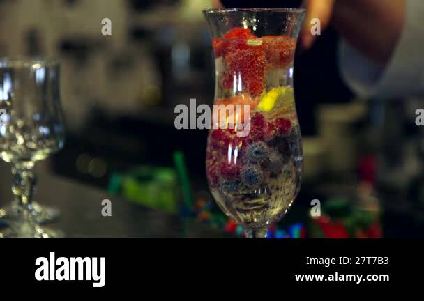 Red Syrup is Poured into a Glass with Fresh Berries and Lemonade. The ...