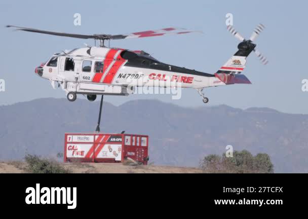 A CAL FIRE helicopter works tirelessly to combat a wildfire in ...